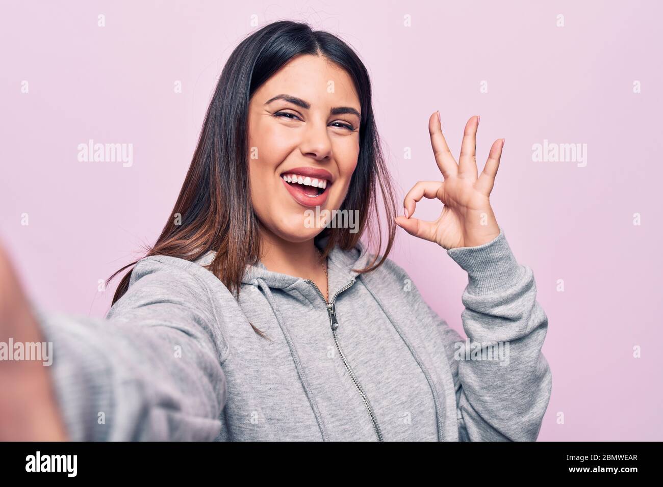 Young beautiful brunette sporty woman make selfie by the camera over ...