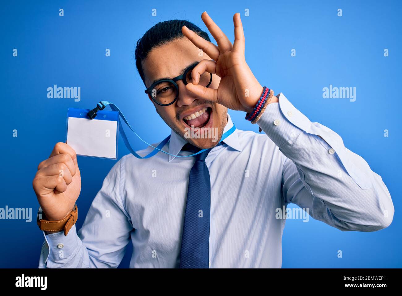 Young brazilian call center agent man holding id identification card ...