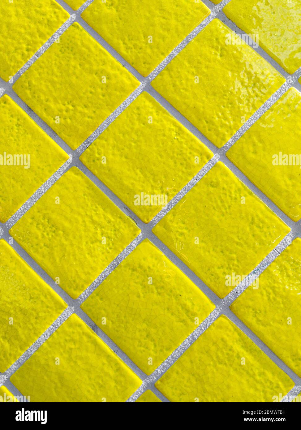 Yellow tiled wall pattern with textured glazed surface Stock Photo - Alamy