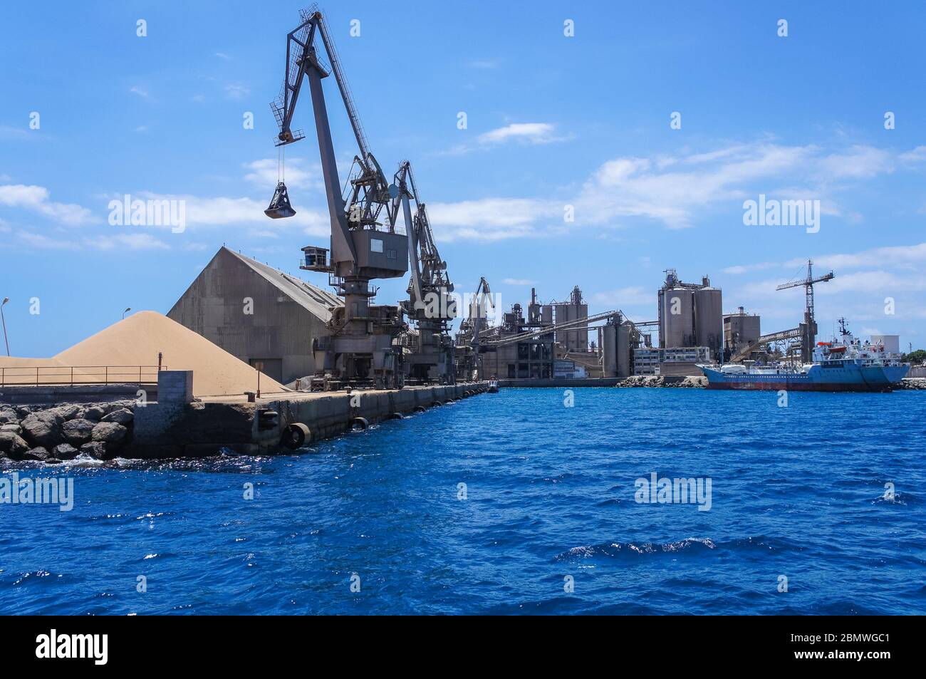 Coastal industrial mining factory with its port and transport ship ...