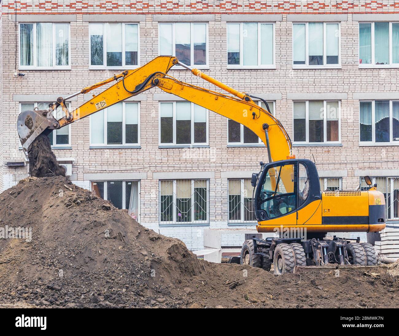 Excavator digs a hole on the construction site territory Stock Photo ...