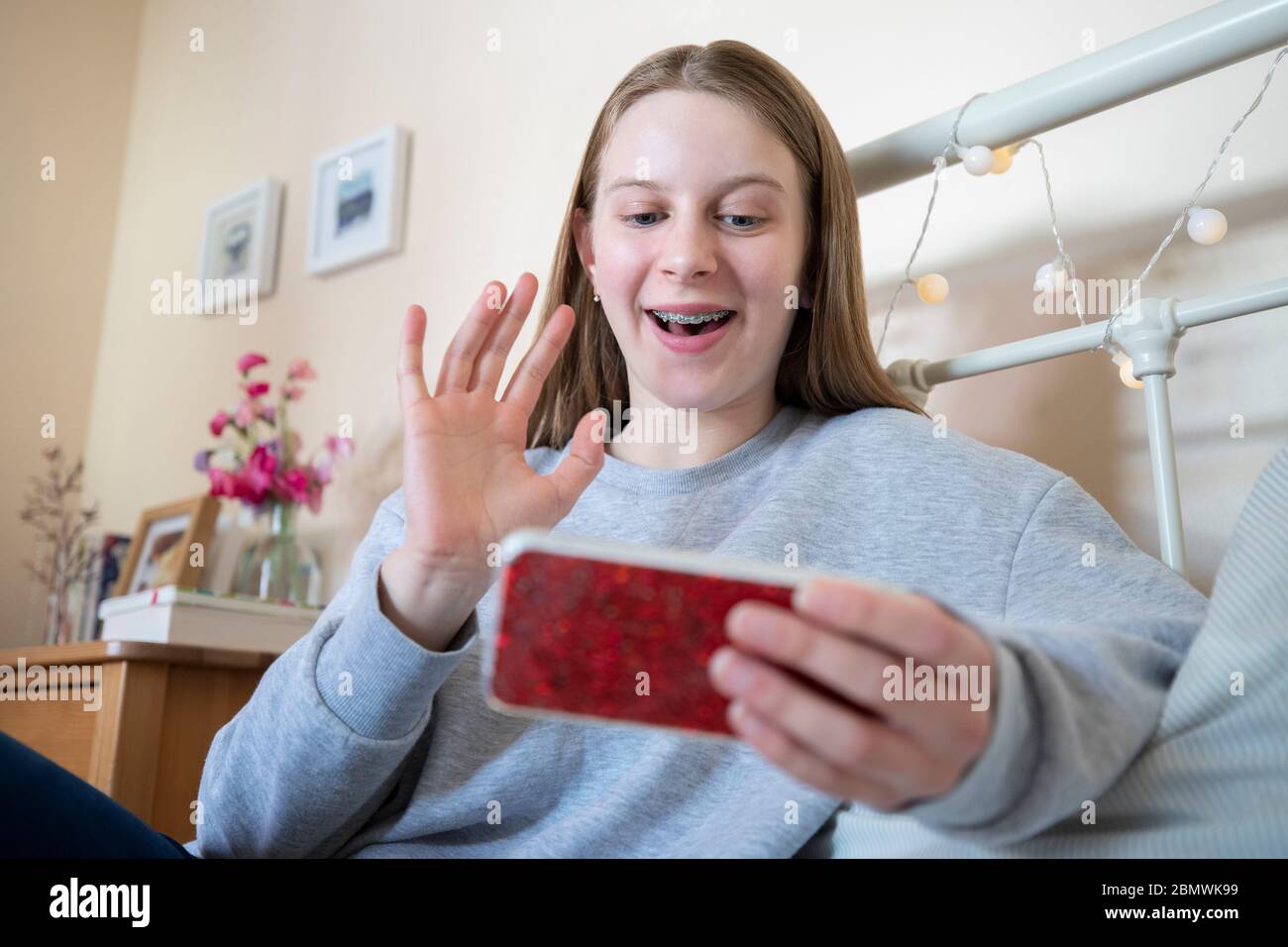 Smiling Teenage Girl In Bedroom Talking With Friends On Social Media ...