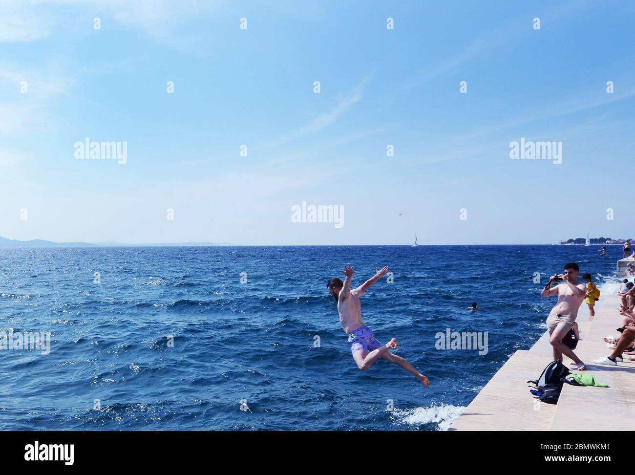 Tourist enjoying the Adriatic sea views from the Nova Riva promenade in ...