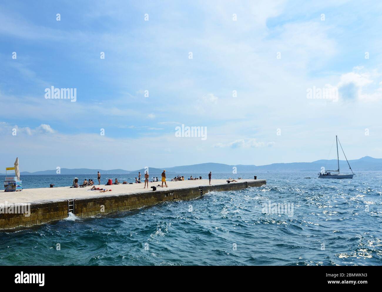 Tourist enjoying the Adriatic sea views from the Nova Riva promenade in ...