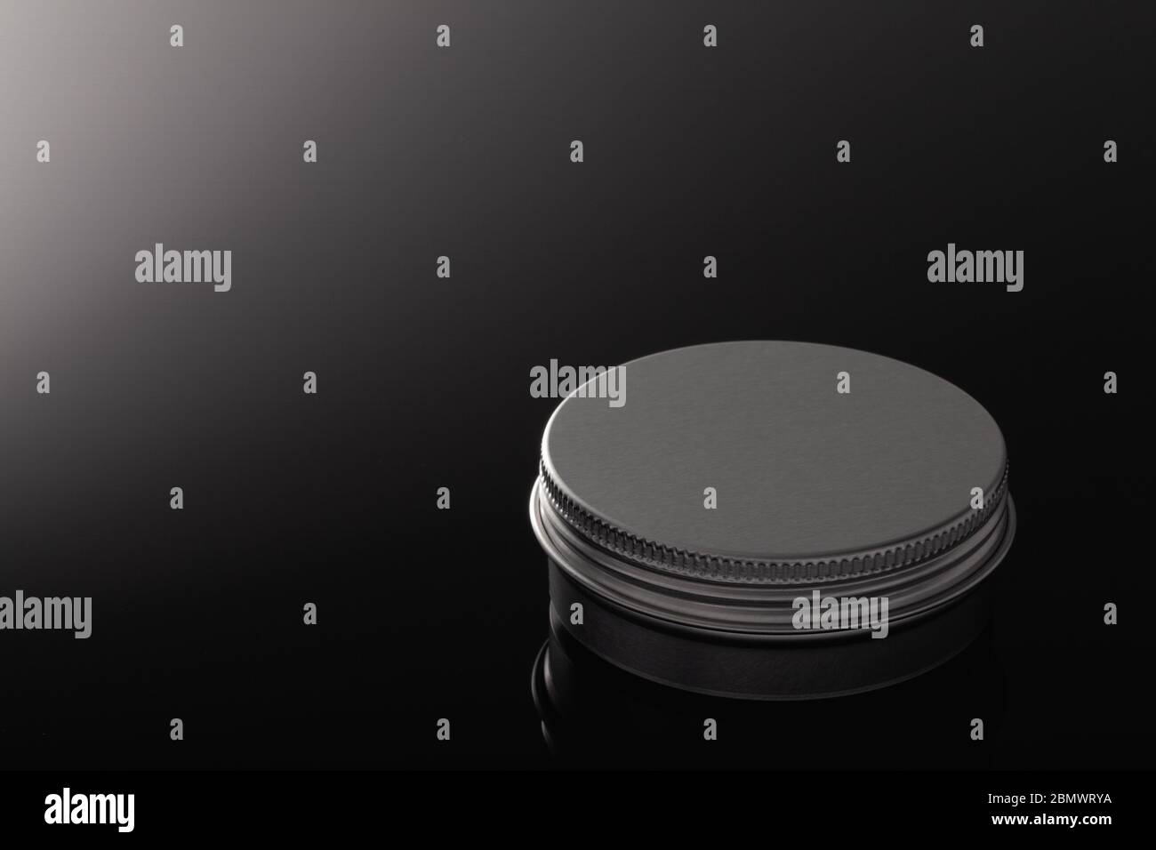 Silver metal containers for cosmetics isolated on the black glass desk ...