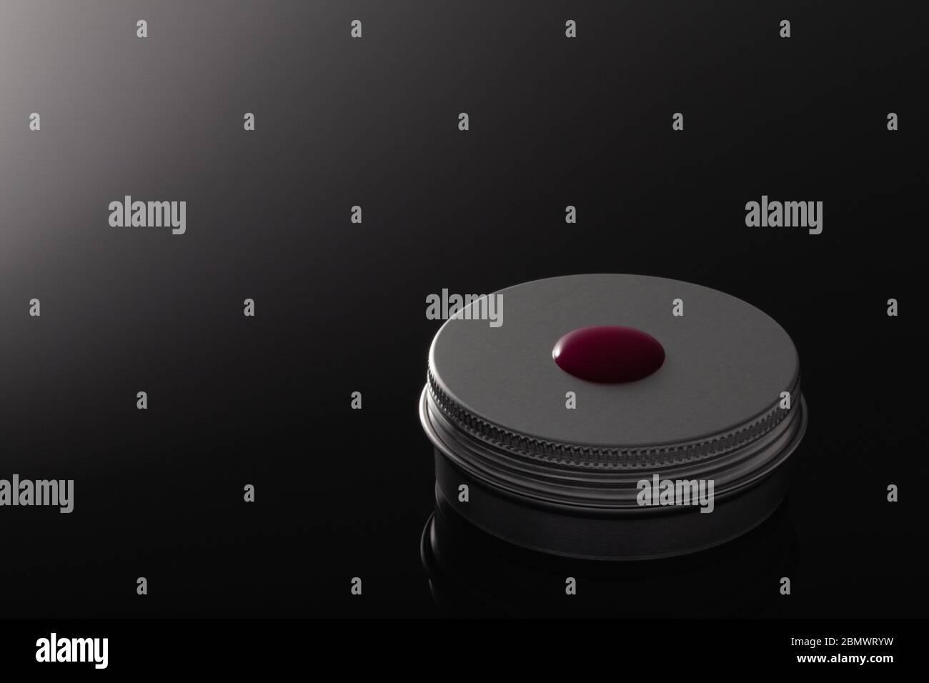 Silver metal containers for cosmetics and a drop of blood isolated on ...