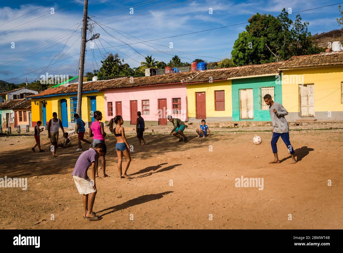 Children playing football against the background of colourful houses in ...