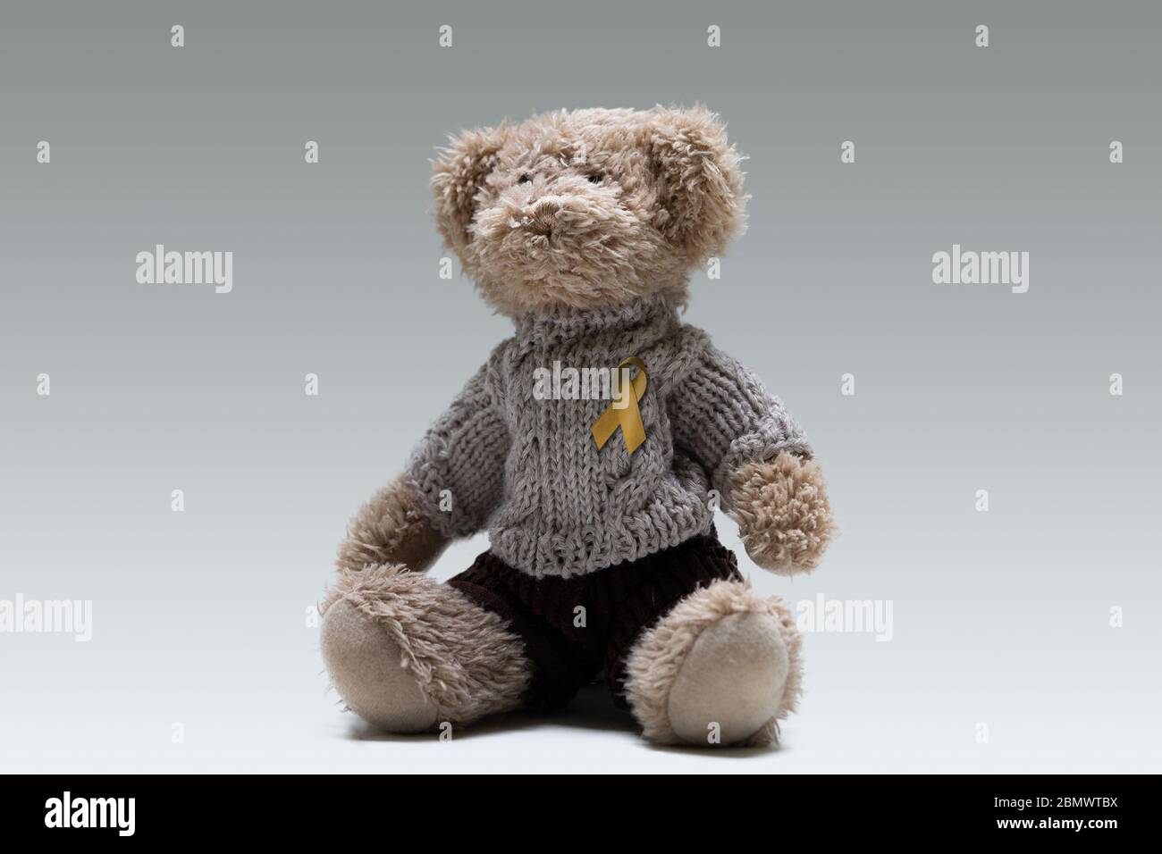 Teddy Bear With Golden Yellow Ribbon on Gray Background. Campaign ...