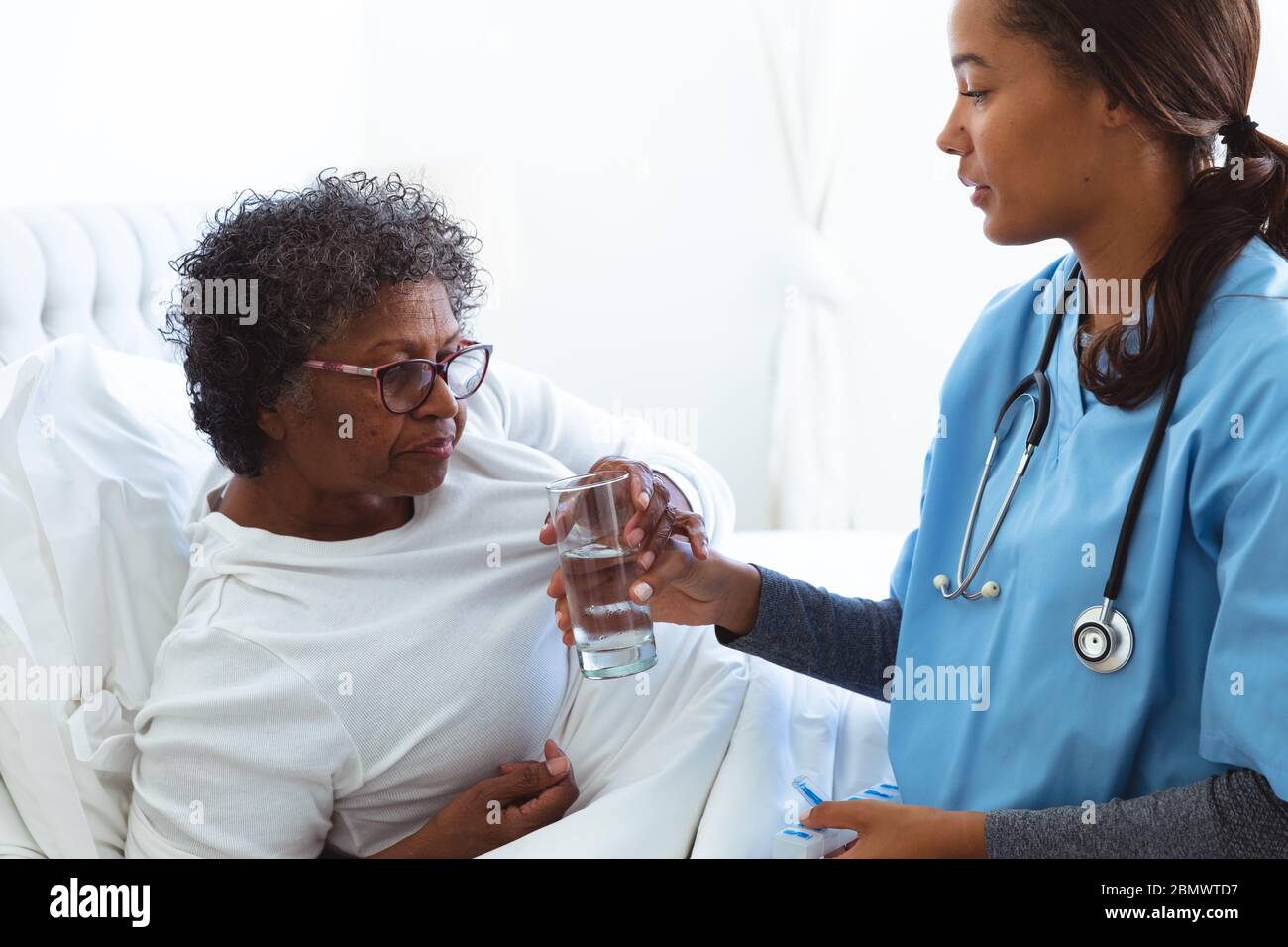 Sick Senior African American woman at home during quarantine lock down ...
