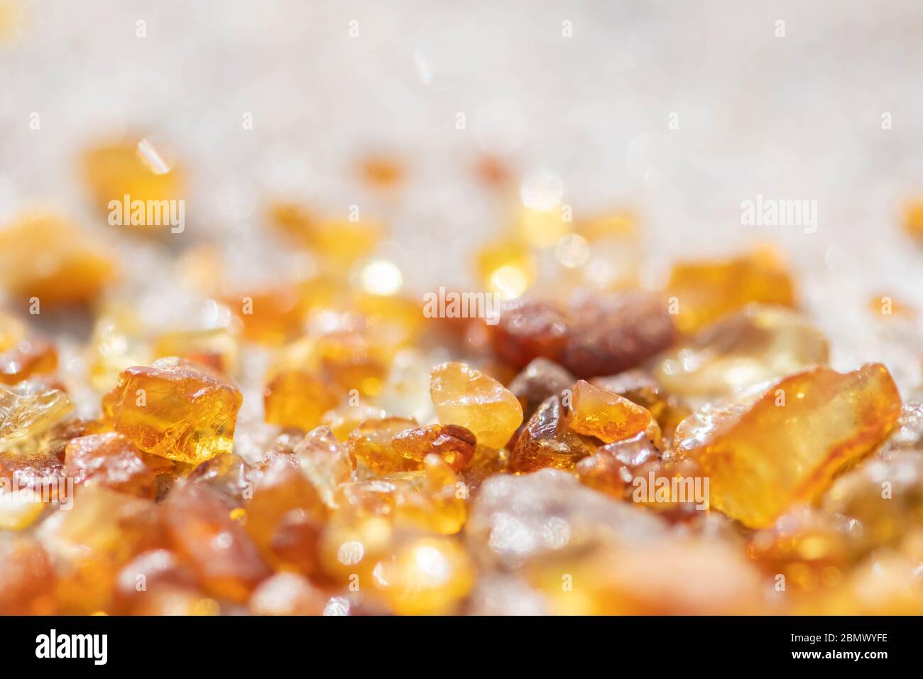 Beautiful pieces of amber on the sandy beach, amber background. close ...