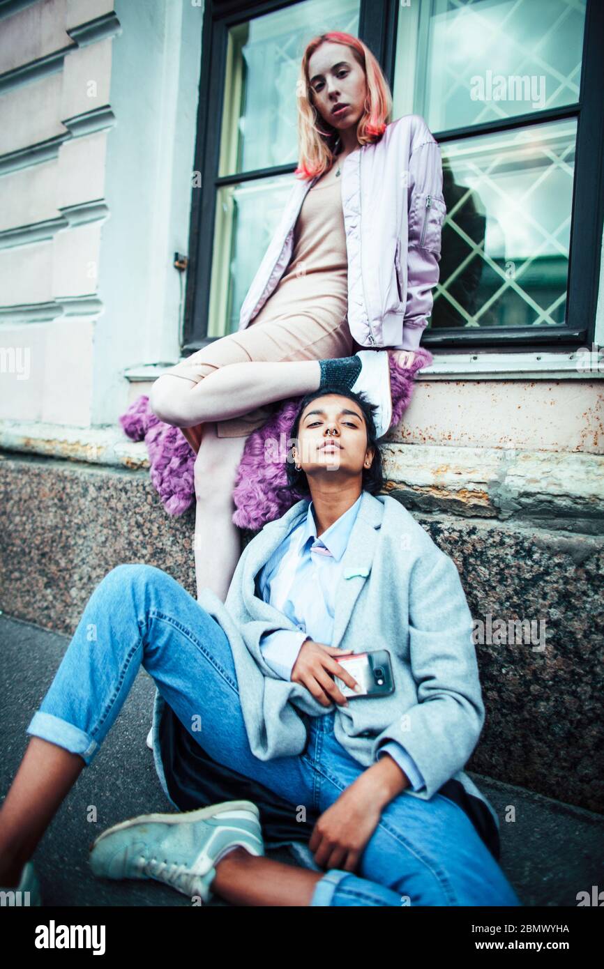 Two teenage girls infront of university building smiling, having fun ...