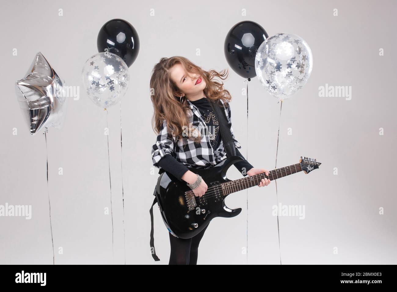 Cute baby girl rock star playing electric guitar and singing song ...