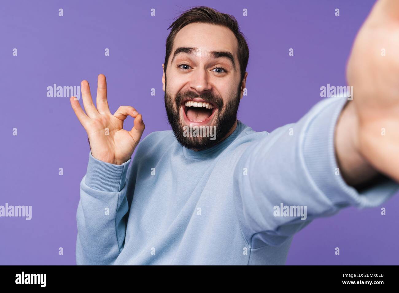 Image of a happy emotional handsome young man isolated over purple ...