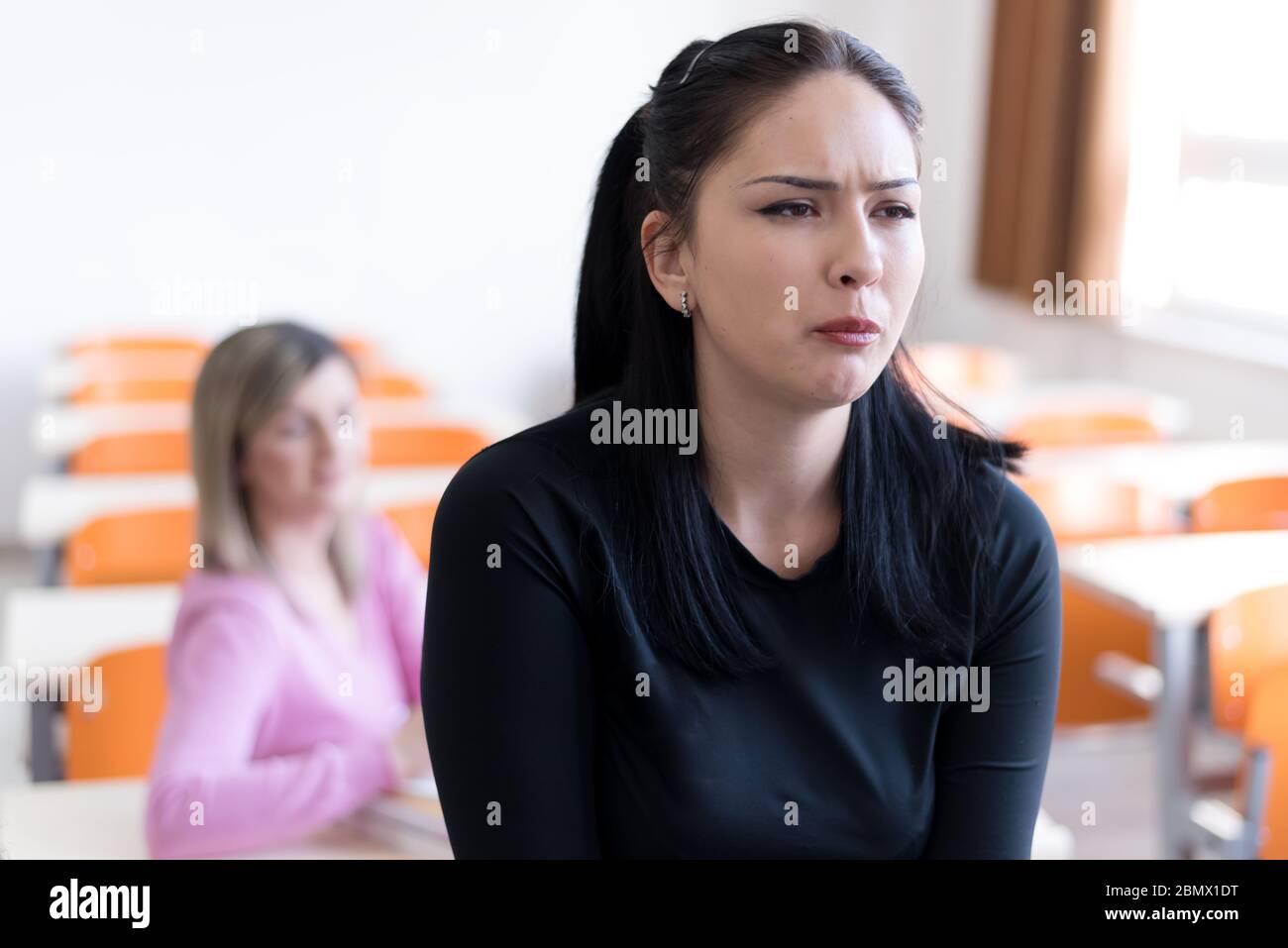 Sadly student girl standing in classroom and Crying after test ...