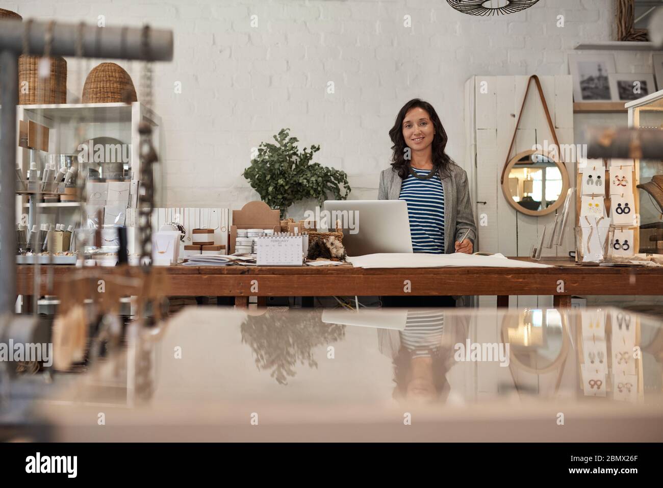Smiling Asian woman working behind a counter in her shop Stock Photo ...