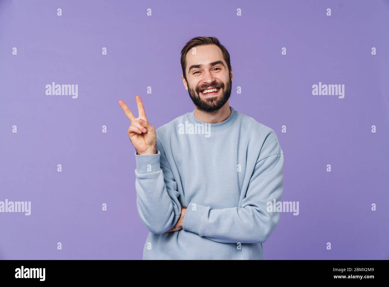 Image of a handsome positive happy young man isolated over purple wall ...