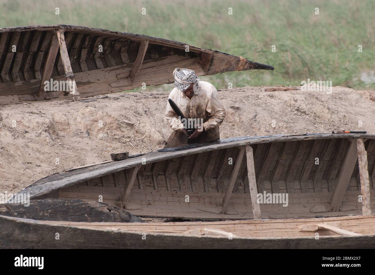Boatmen fix their traditional boats (Mashoof), using bitumen to seal ...