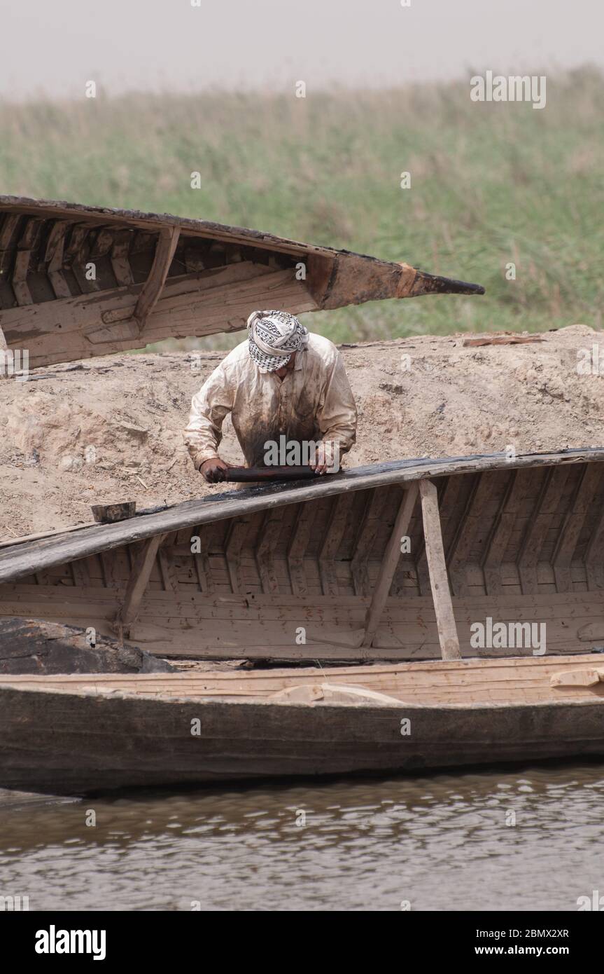 Boatmen fix their traditional boats (Mashoof), using bitumen to seal ...