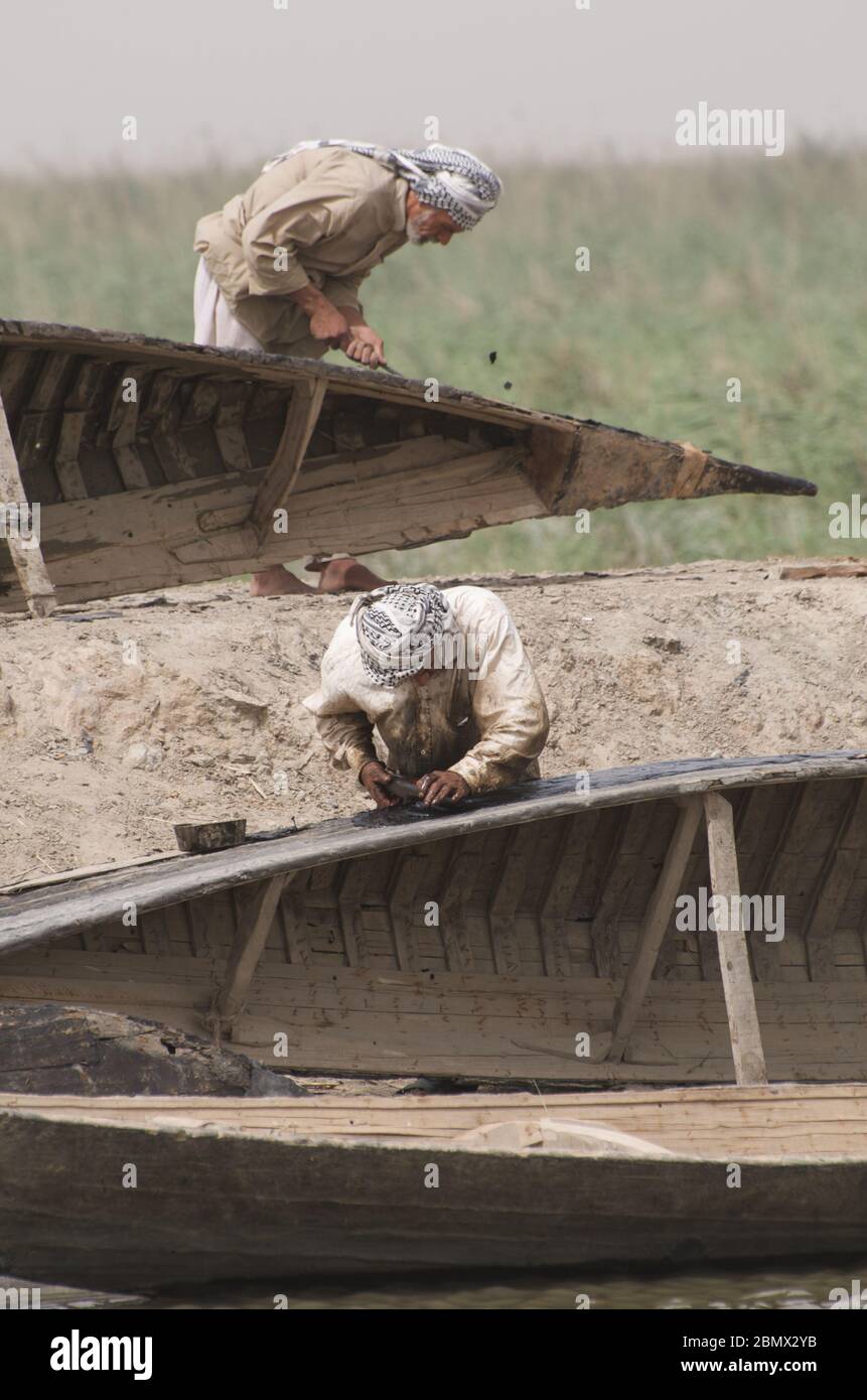 Boatmen fix their traditional boats (Mashoof), using bitumen to seal ...