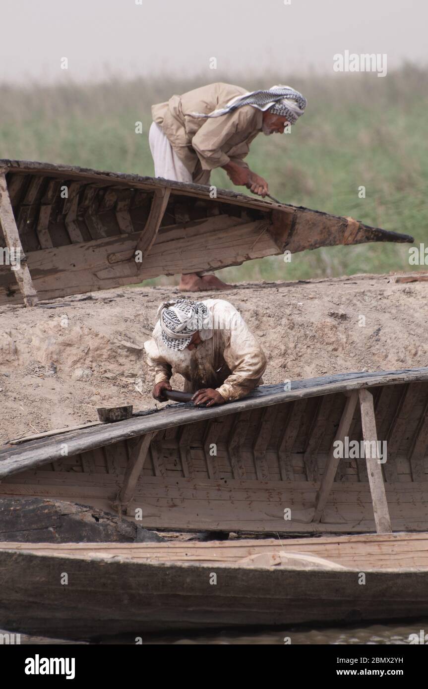 Boatmen fix their traditional boats (Mashoof), using bitumen to seal ...