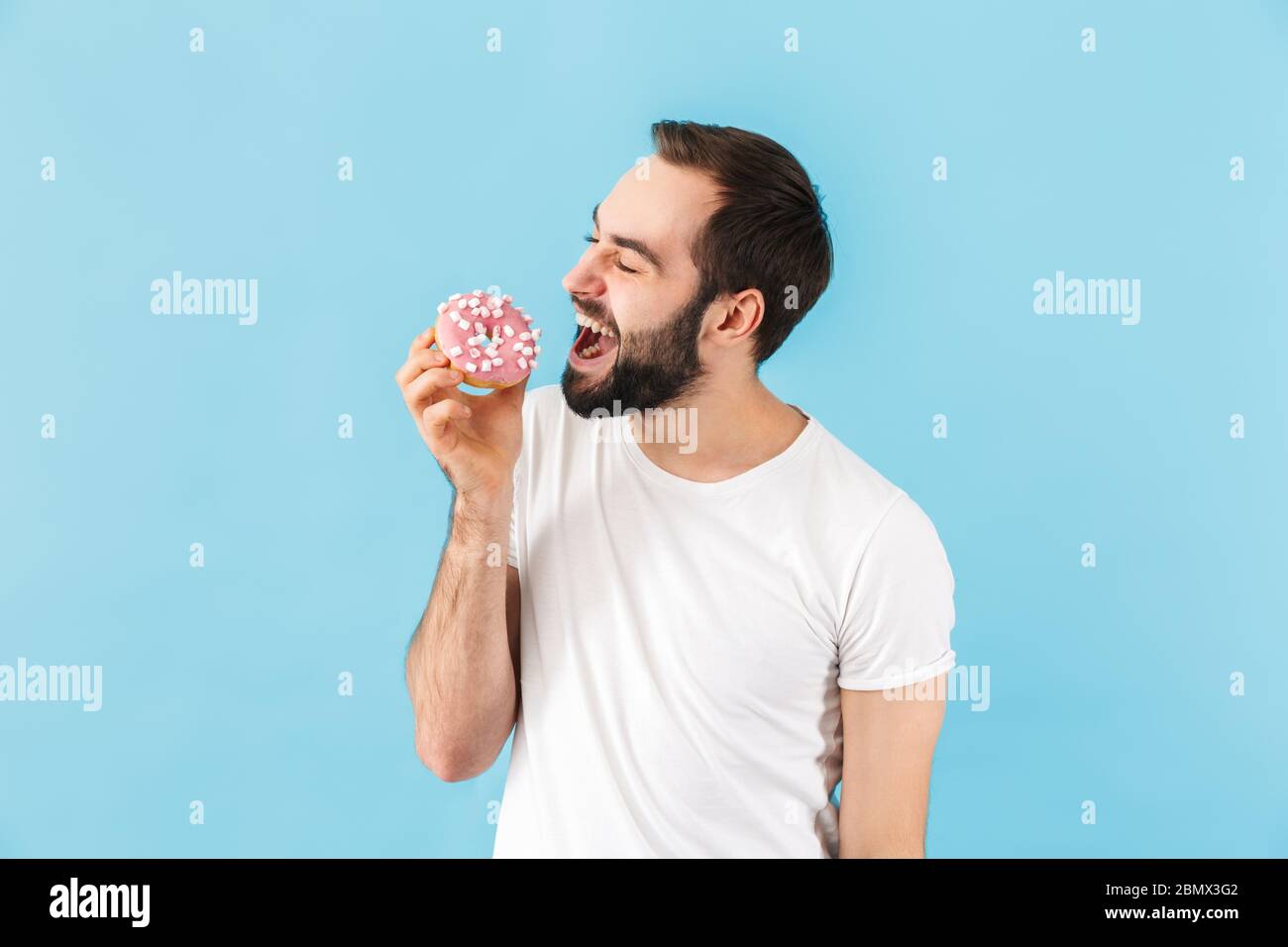 Photo of young happy positive man isolated over blue wall background ...
