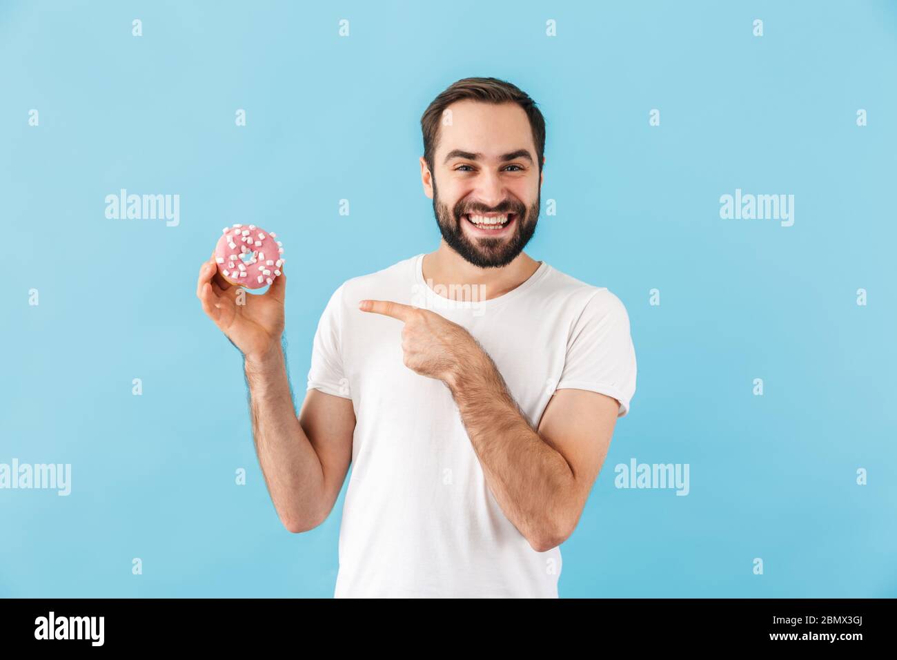 Image of young cheery happy man isolated over blue wall background ...