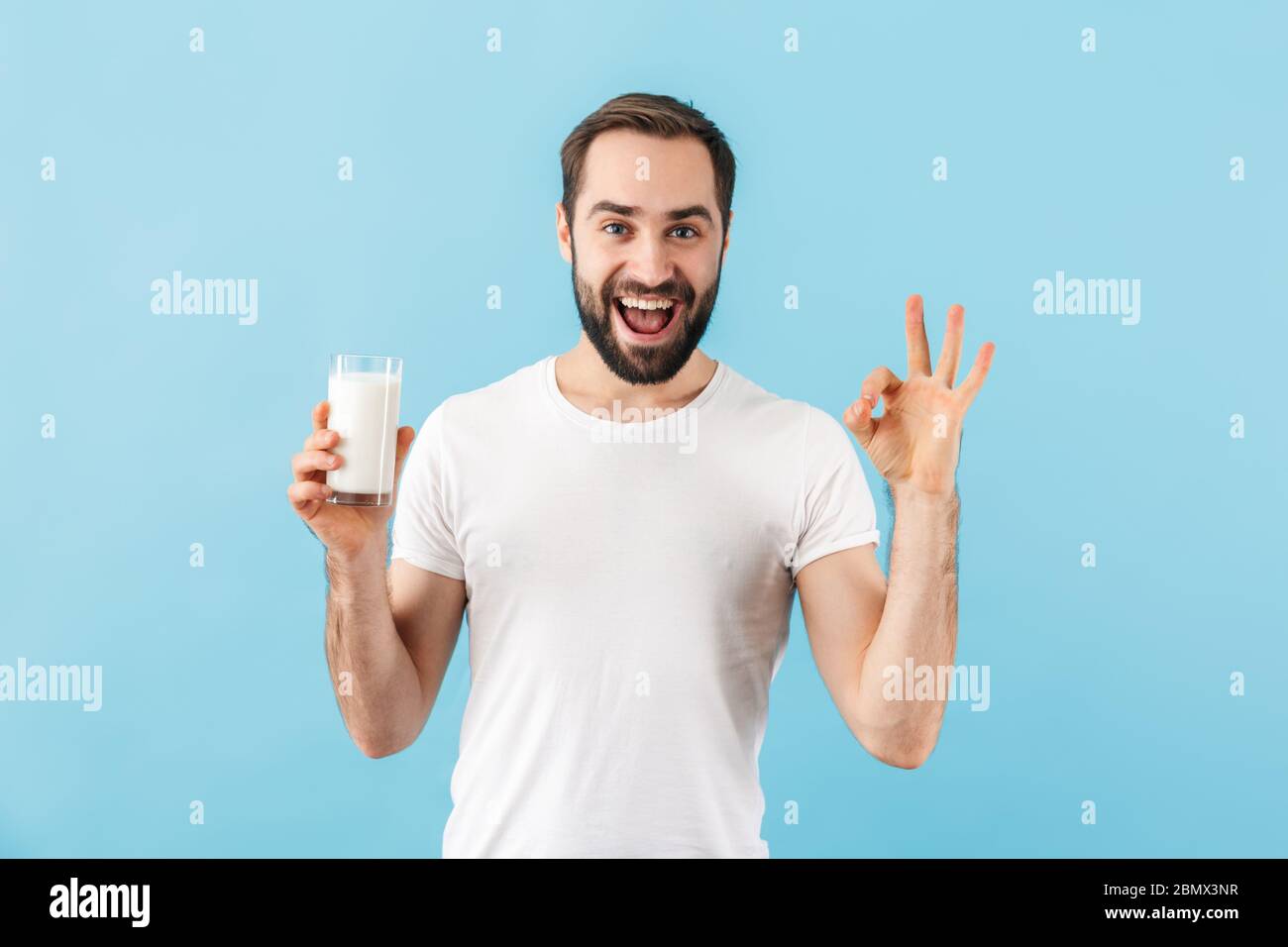 Image of young happy pleased man isolated over blue wall background ...