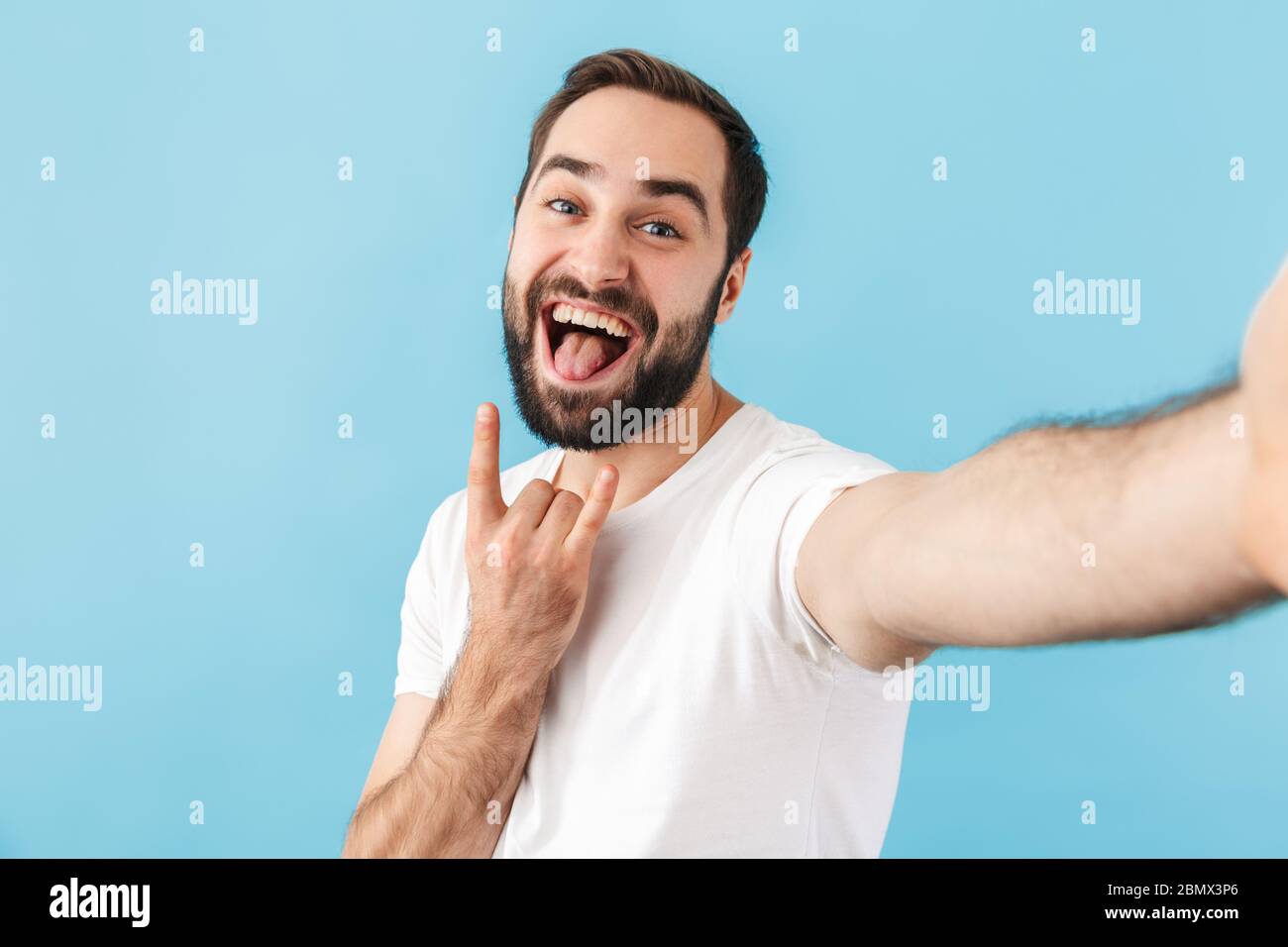 Image of young happy man isolated over blue wall background take a ...