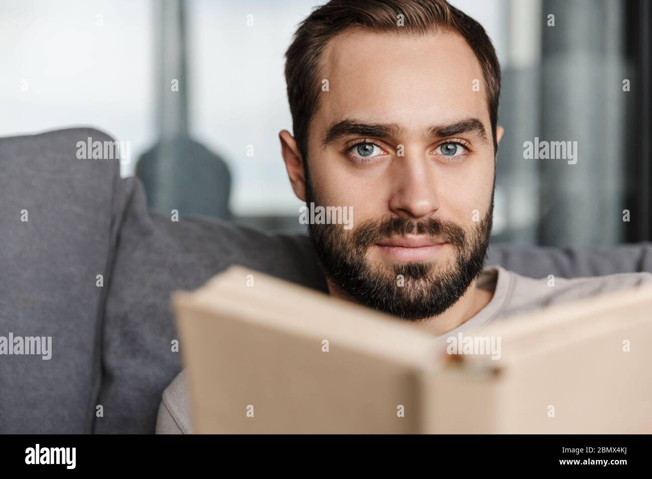 Image of a serious concentrated young man indoors at home on sofa ...
