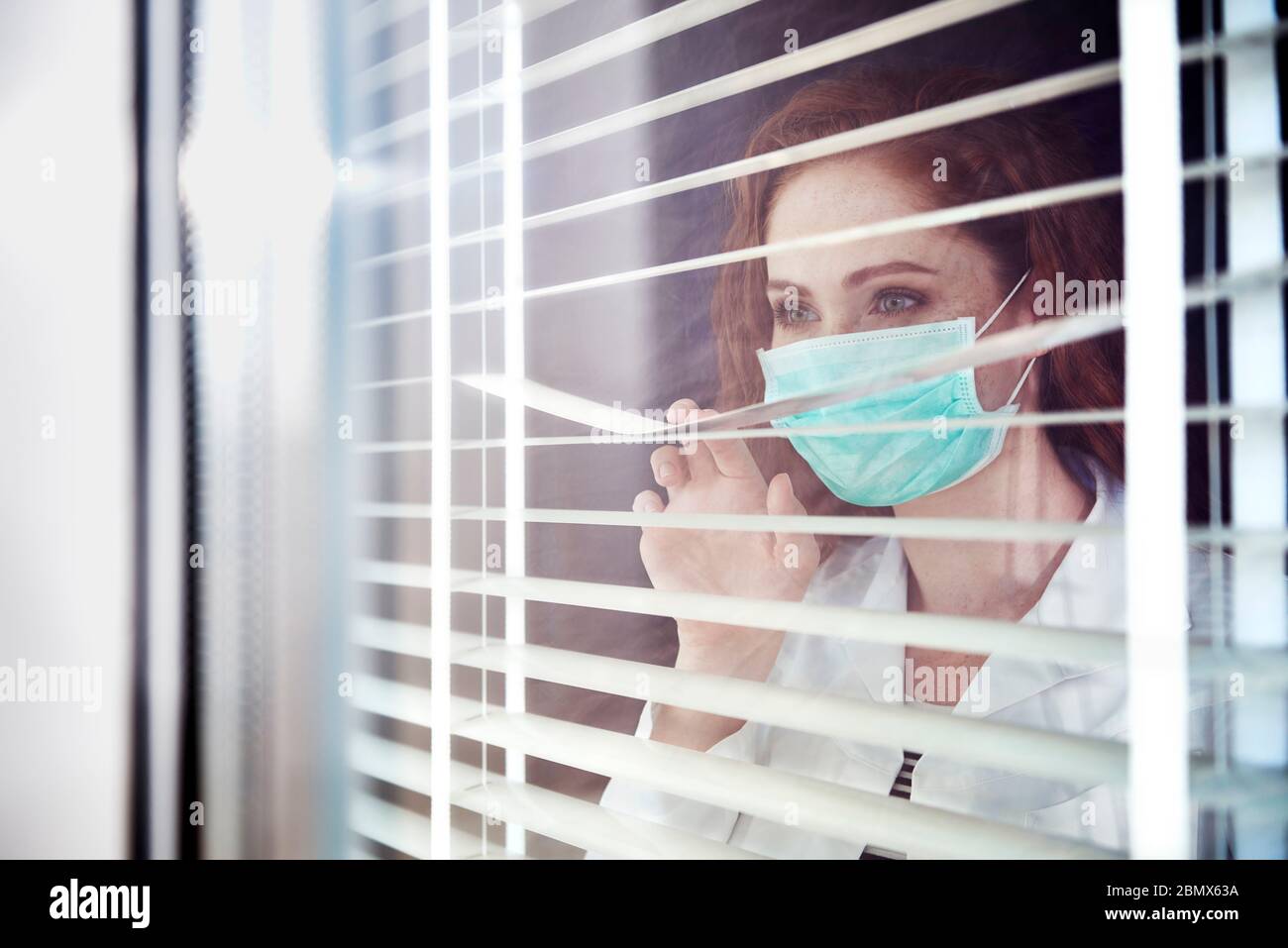 Female doctor looking through the window Stock Photo - Alamy