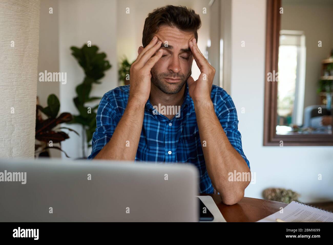 Man looking stressed while working remotely from home Stock Photo - Alamy