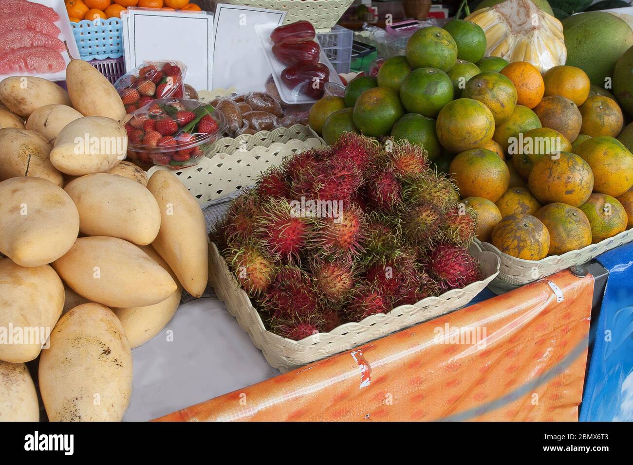 Fresh ripe rambutan, mango, tangerines are sold at a kiosk in Thailand ...