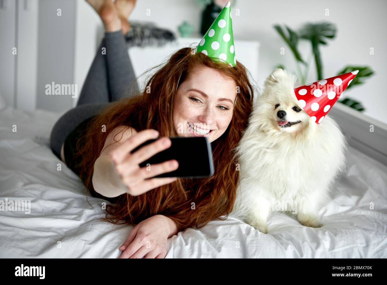 Woman taking birthday selfie with her pet dog Stock Photo - Alamy
