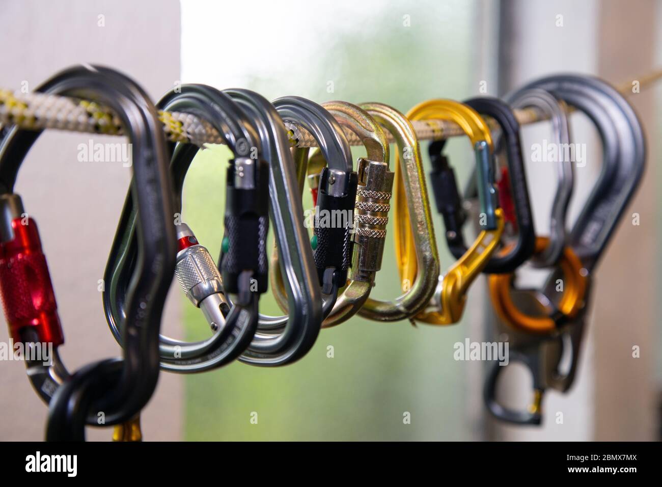 Safety carabiners of various manufacturers are suspended on a safety ...