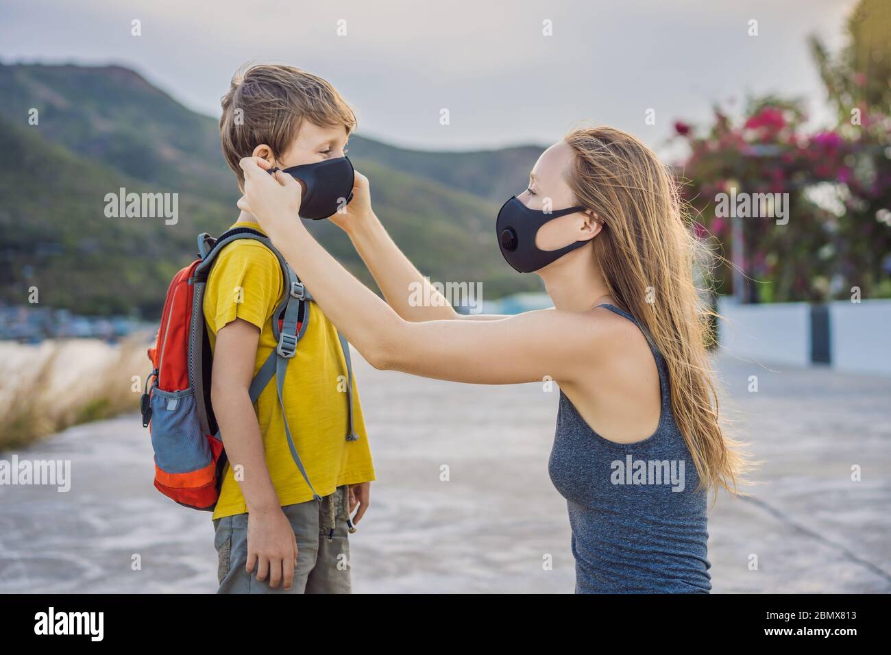 Mother puts her child a face protective mask on the street. Stop the ...