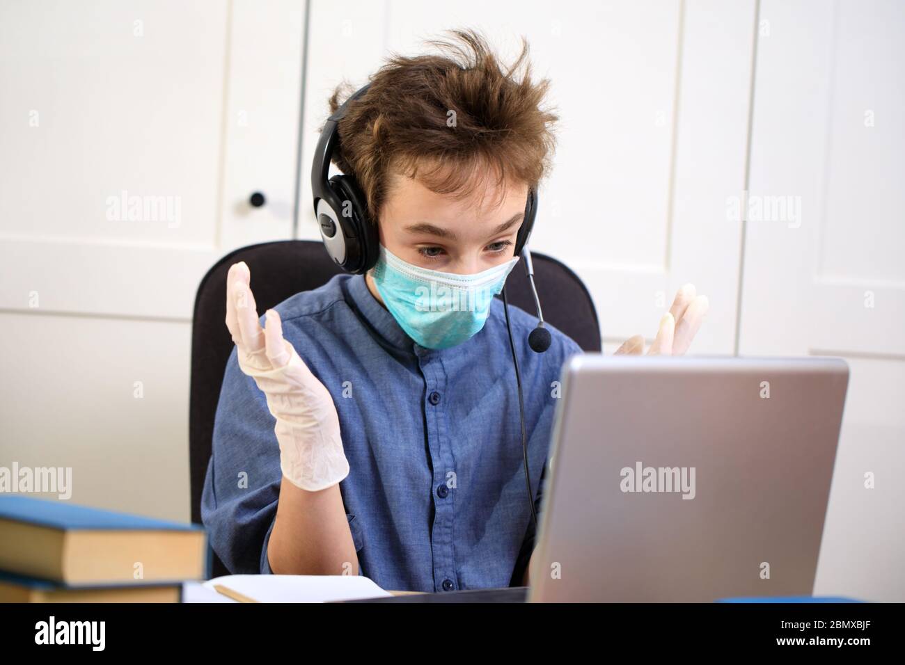 Distance learning online education. schoolboy in medical mask studying ...