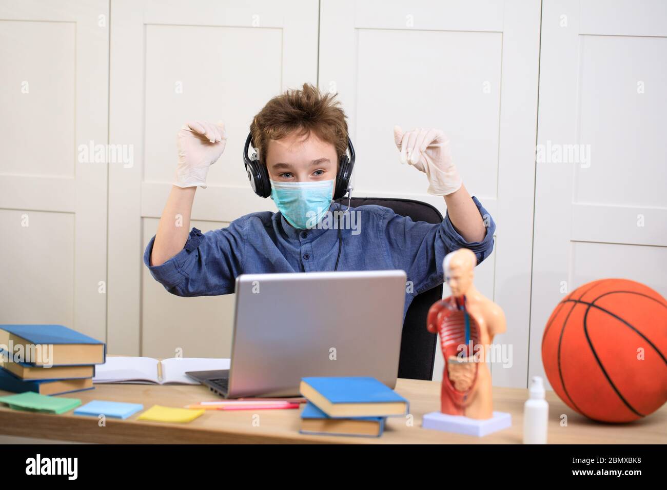 Distance learning online education. schoolboy in medical mask studying ...