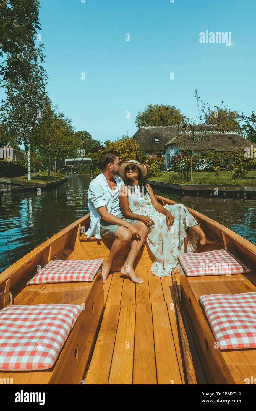 Giethoorn Netherlands couple visit the village with a boat ,view of famous village with canals ...