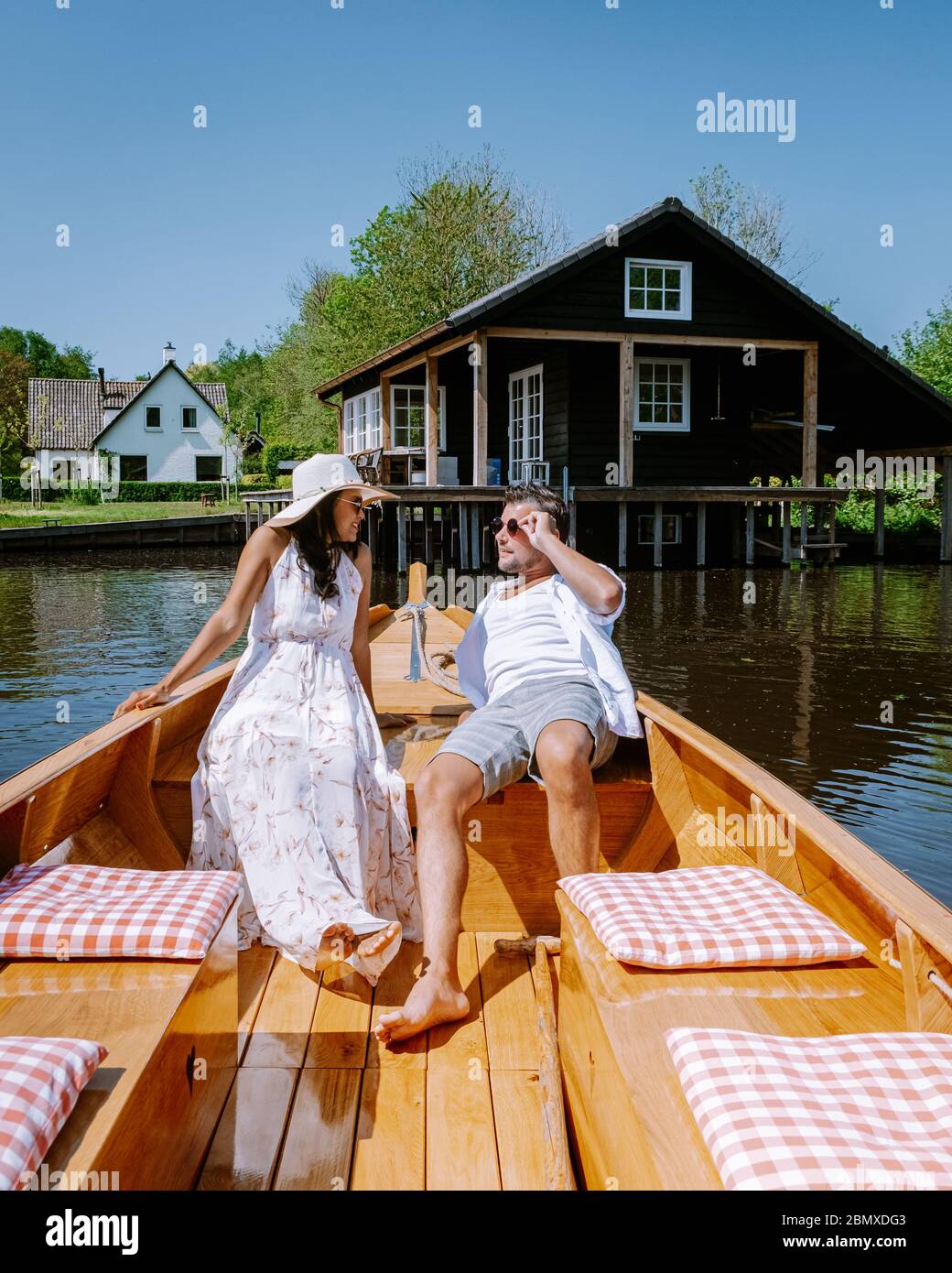 Giethoorn Netherlands couple visit the village with a boat ,view of famous village with canals ...