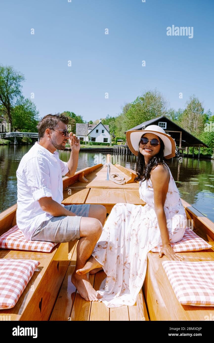 Giethoorn Netherlands couple visit the village with a boat ,view of famous village with canals ...