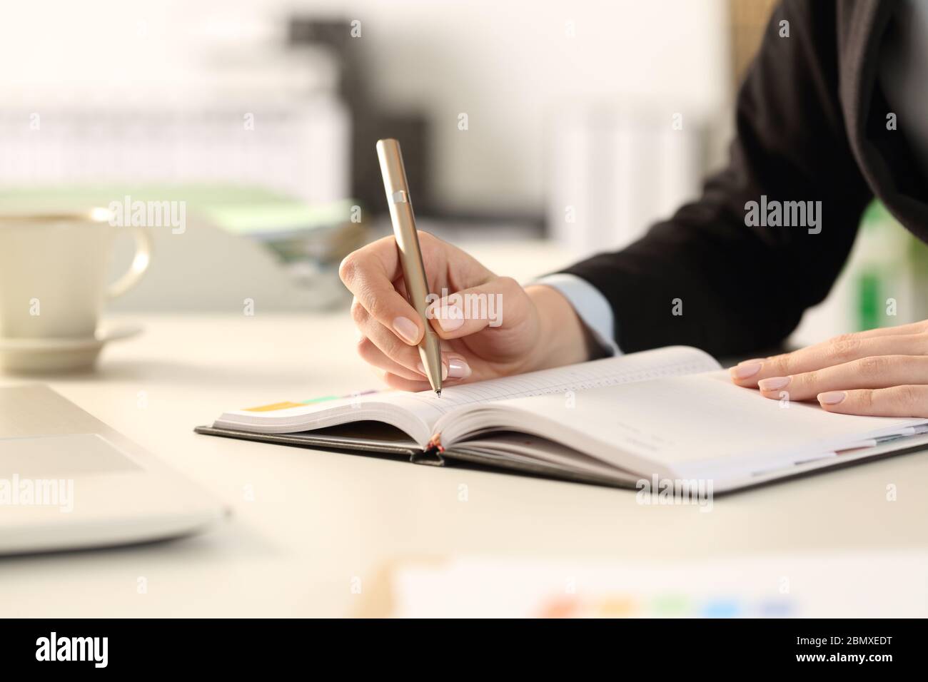 Close up of business woman hands taking notes writing on agenda sitting ...