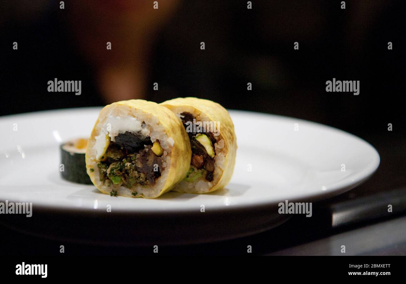 Prepared rolls of sustainable sushi sit on plates ready to serve at ...
