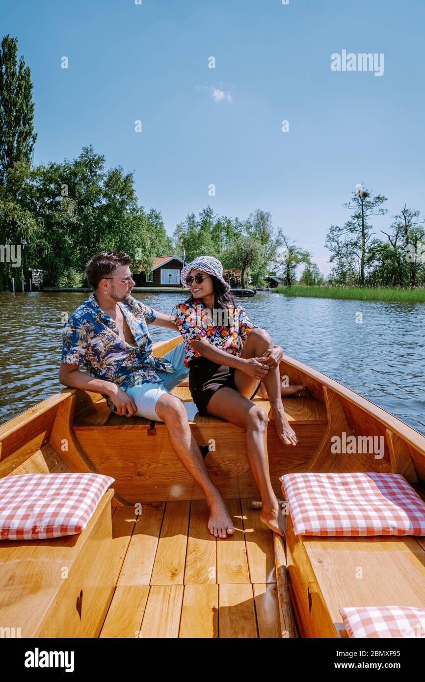 Giethoorn Netherlands couple visit the village with a boat ,view of famous village with canals ...