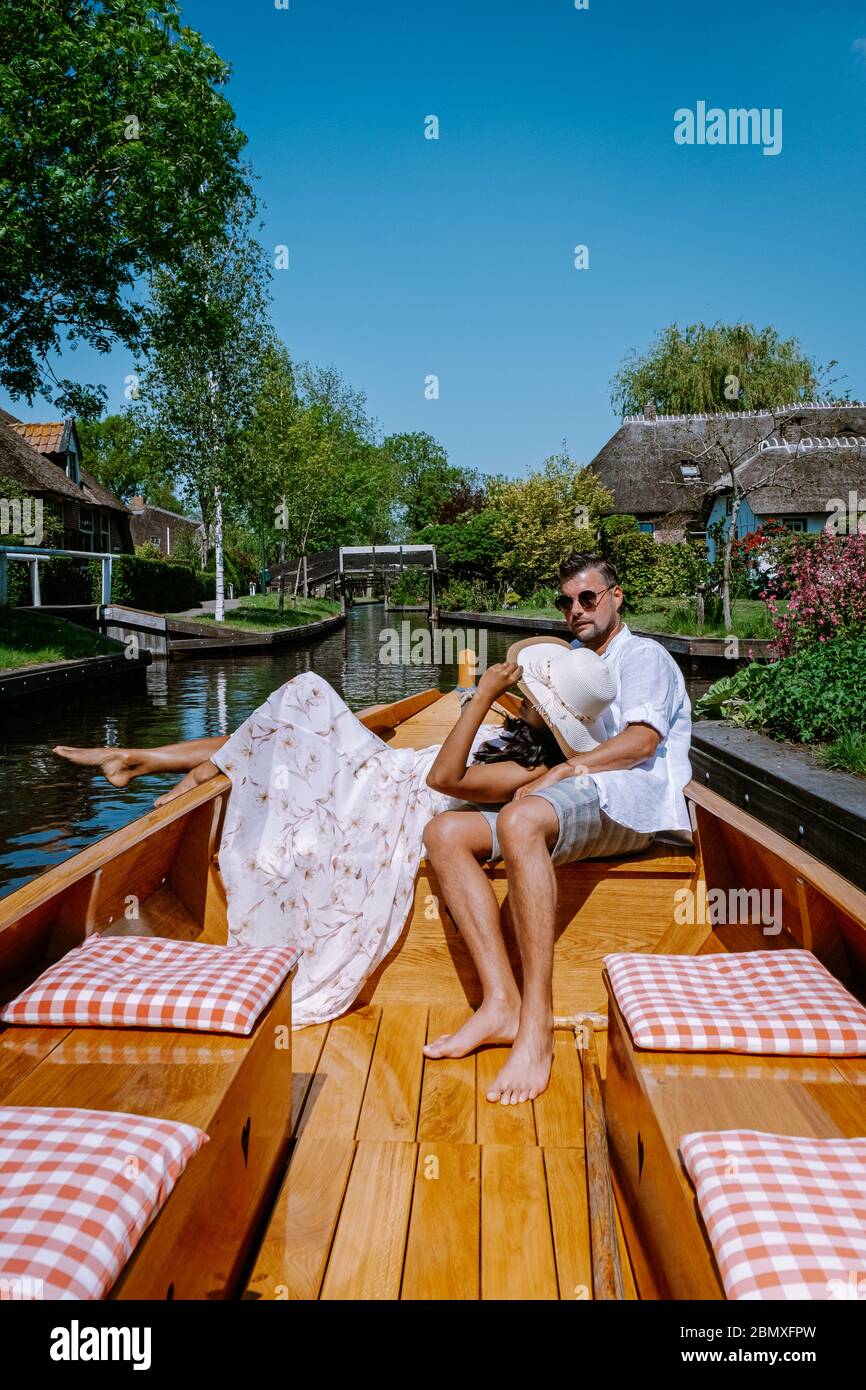 Giethoorn Netherlands couple visit the village with a boat ,view of famous village with canals ...