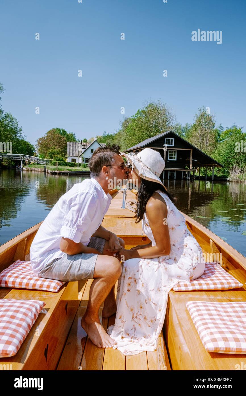 Giethoorn Netherlands couple visit the village with a boat ,view of famous village with canals ...