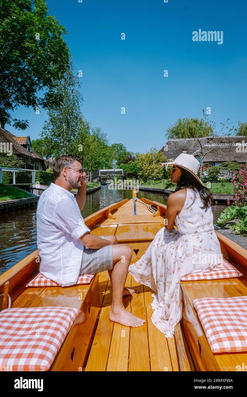 Giethoorn Netherlands couple visit the village with a boat ,view of famous village with canals ...