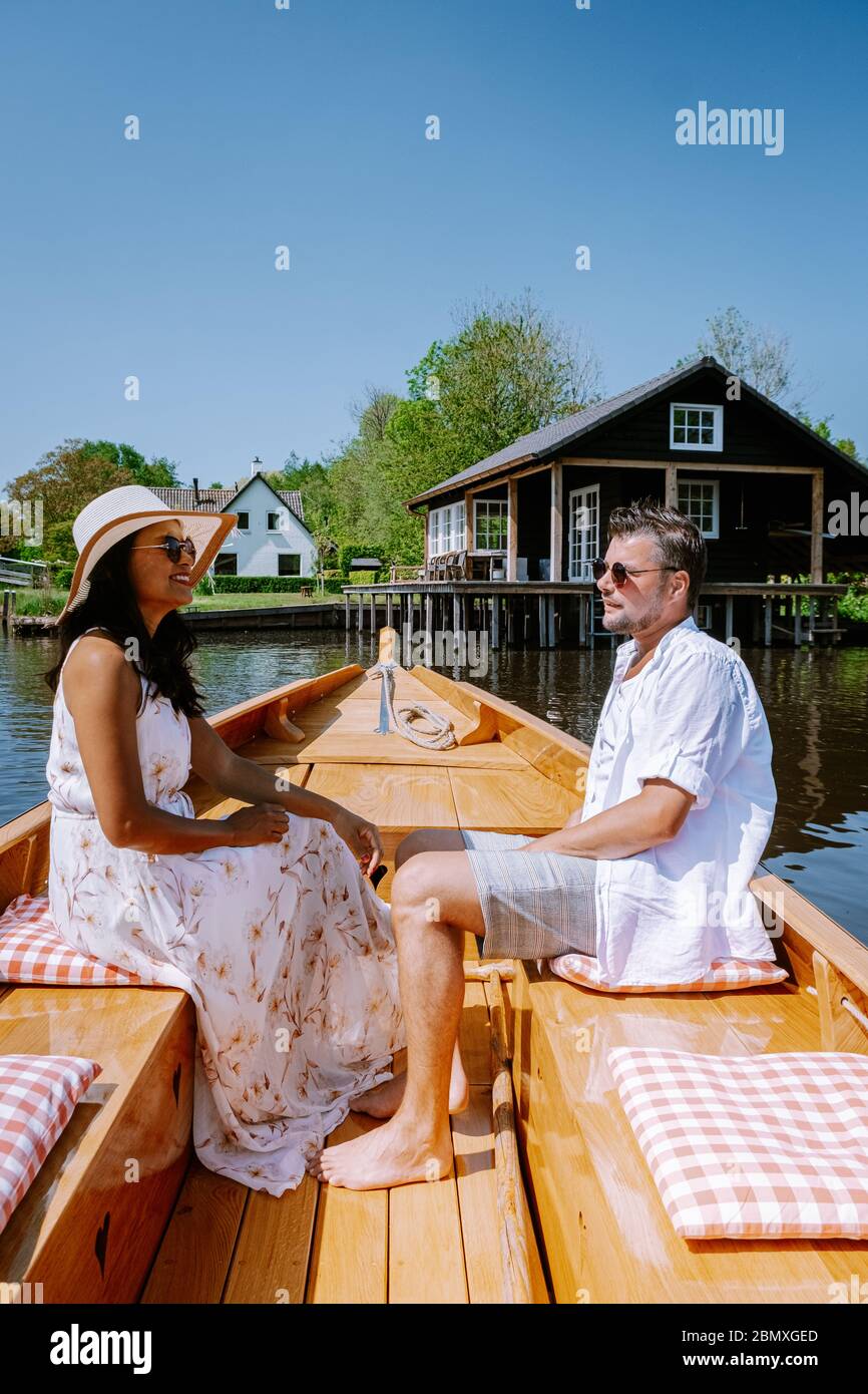 Giethoorn Netherlands couple visit the village with a boat ,view of famous village with canals ...