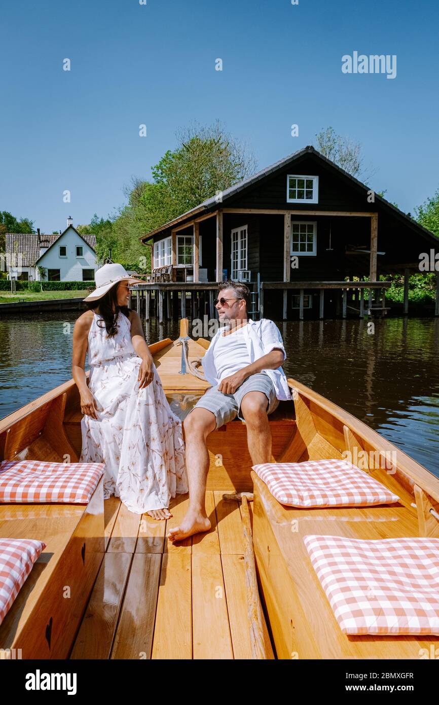 Giethoorn Netherlands couple visit the village with a boat ,view of famous village with canals ...