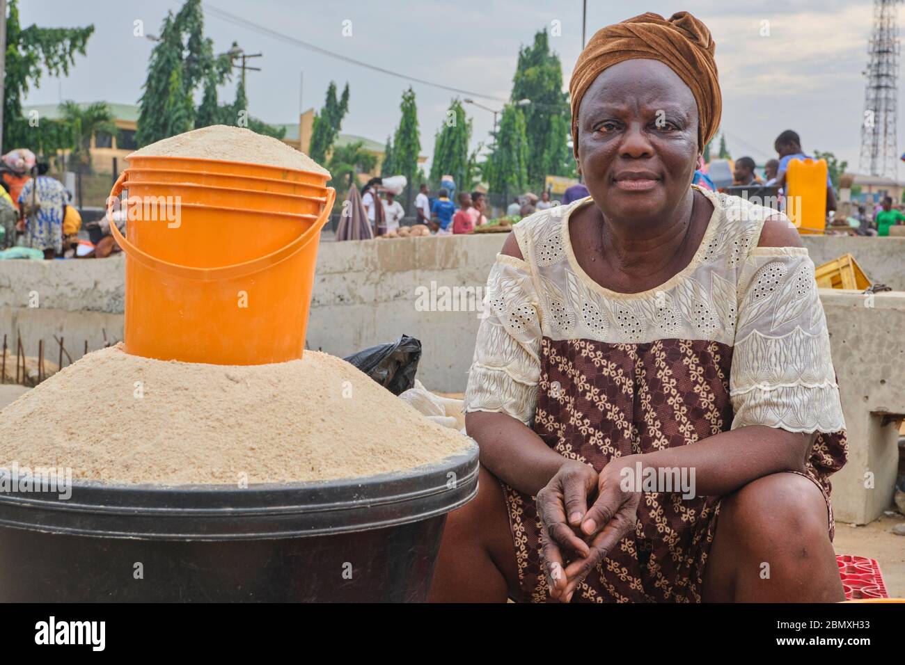 A woman pose for a photo at a makeshift market where she sells rice ...