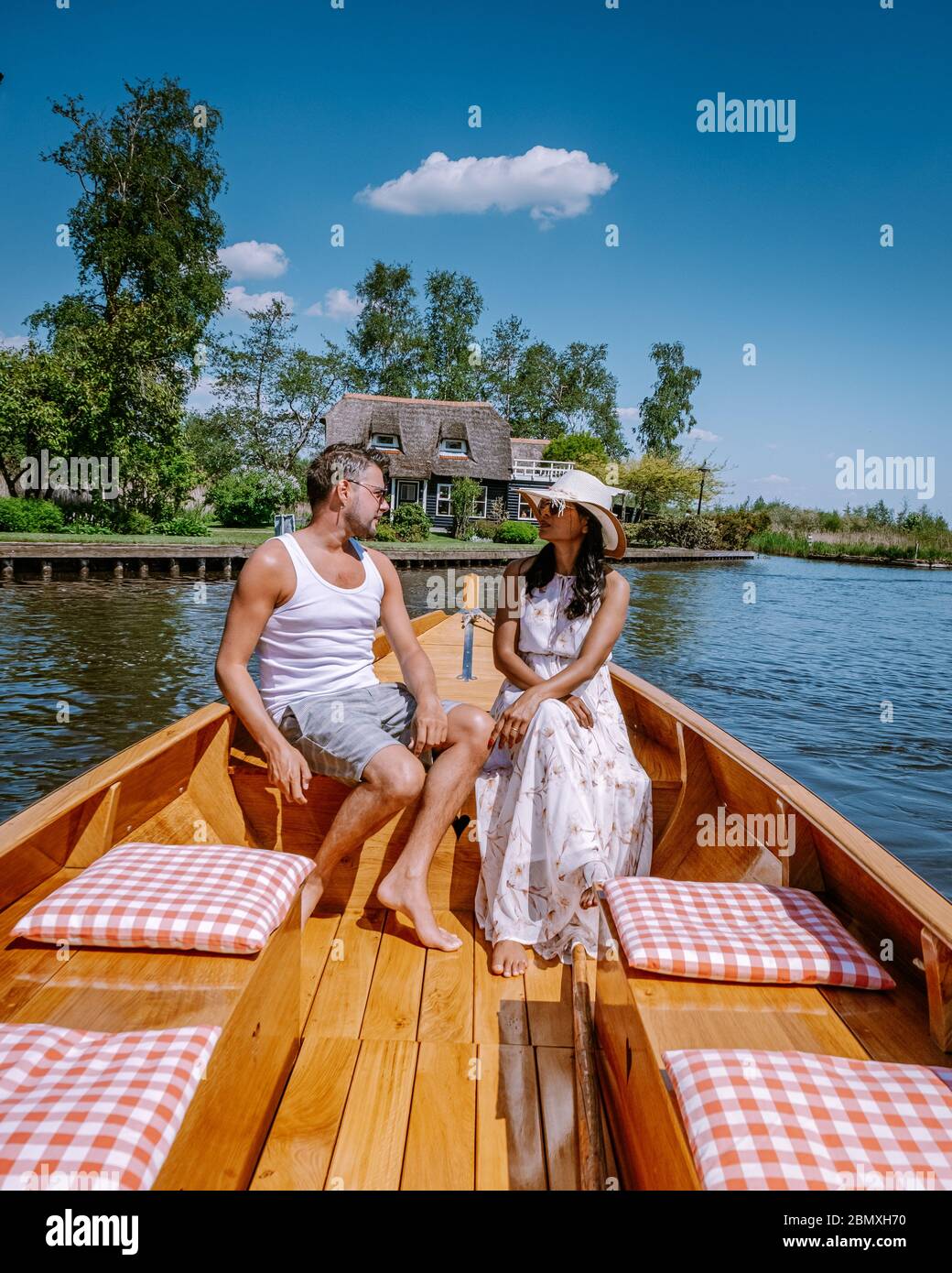 Giethoorn Netherlands couple visit the village with a boat ,view of famous village with canals ...